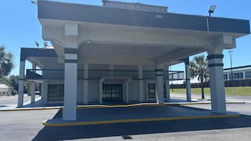 Um posto de gasolina com toldo, várias bombas de combustível e uma câmera de segurança.