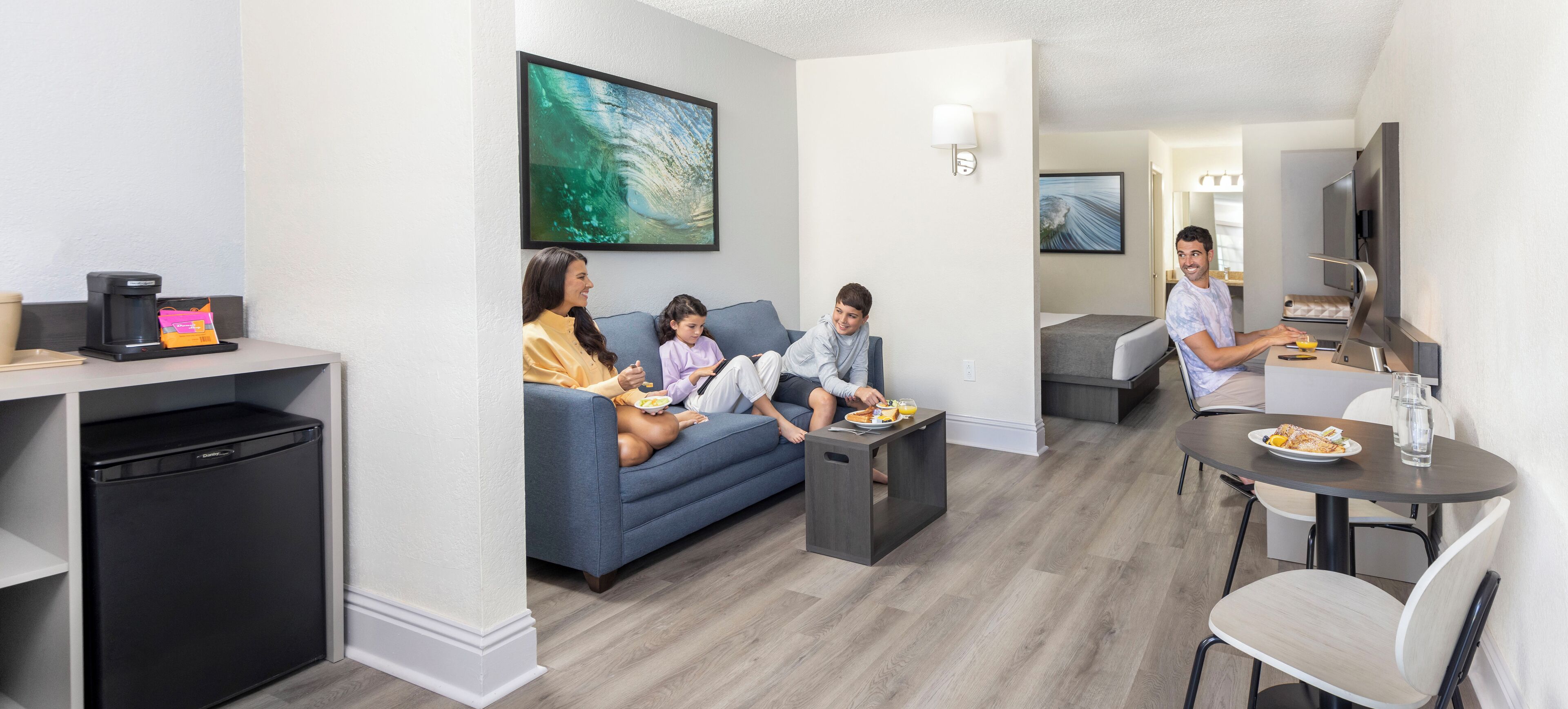 Uma sala de estar moderna com sofá, um espaço para café, uma mesa de jantar e uma televisão.