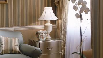 Quarto com sofá, luminária, um objeto decorativo e uma planta.