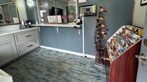 Um banheiro moderno com parede cinza, espelho, toucador com pia e uma planta decorativa.