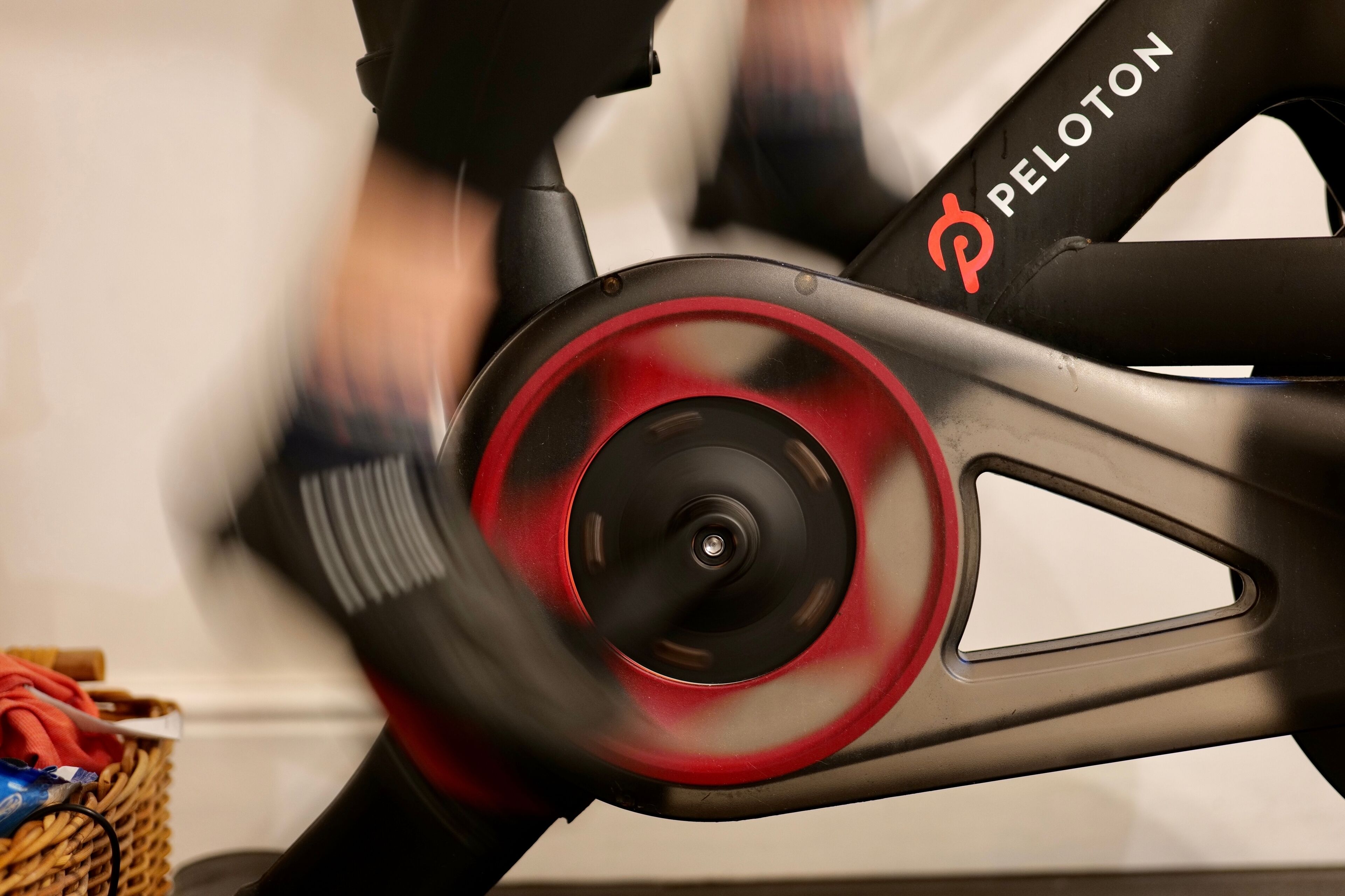 Uma bicicleta ergométrica com o logotipo Peloton e uma cesta com objetos.