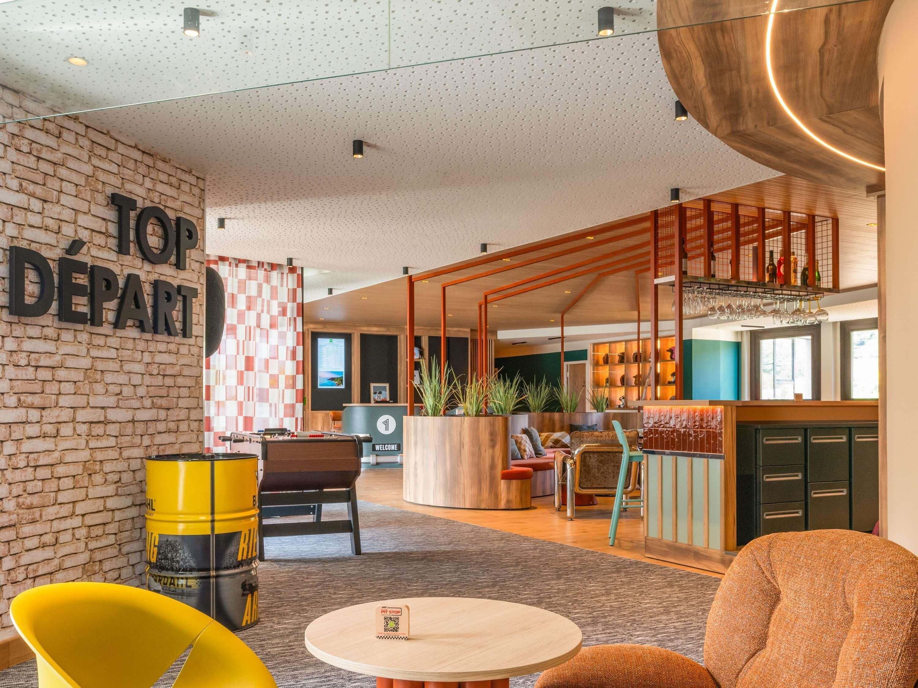 Uma área de estar moderna com parede de tijolos, balcão de recepção e espaço para bar.
