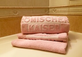 Uma pilha de toalhas cor-de-rosa com o texto 