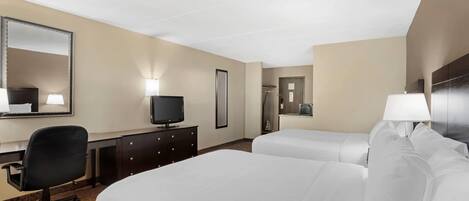 Quarto de hotel com duas camas, uma mesa de trabalho com cadeira, televisão e espelho.
