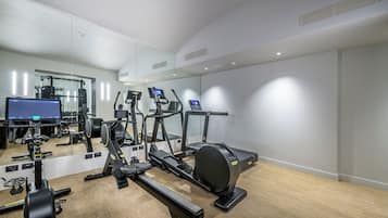 Uma academia moderna com equipamentos de cardio, aparelhos de musculação e um espelho grande na parede.