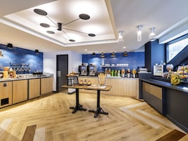 Uma cozinha moderna com armários de madeira, uma ilha central e diversos eletrodomésticos e alimentos.