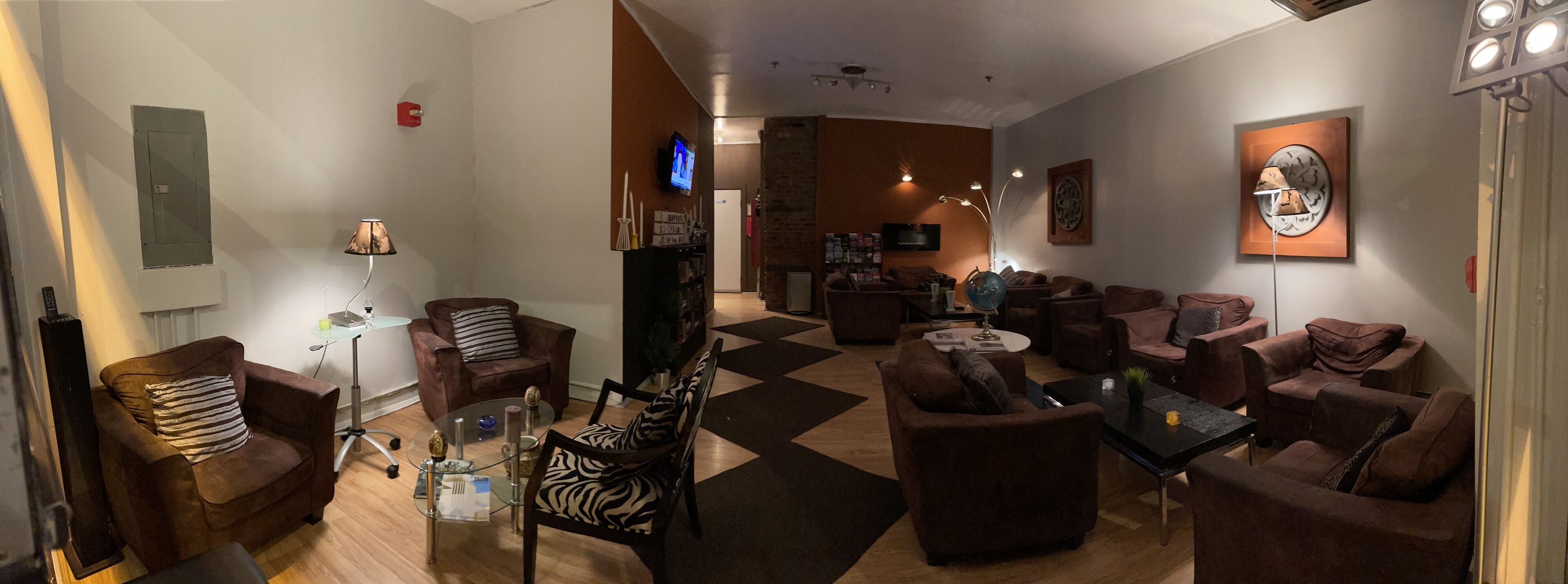 Uma sala de estar moderna com vários sofás, uma mesa de centro e uma televisão.