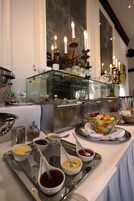 Disposição de buffet com diversos alimentos e acompanhamentos.