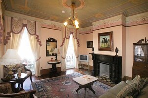 Uma sala de estar tradicional com lareira, um sofá, uma mesa com um livro e uma televisão.