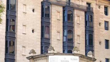 Um edifício histórico com uma placa que indica ser o Plaza Hotel.