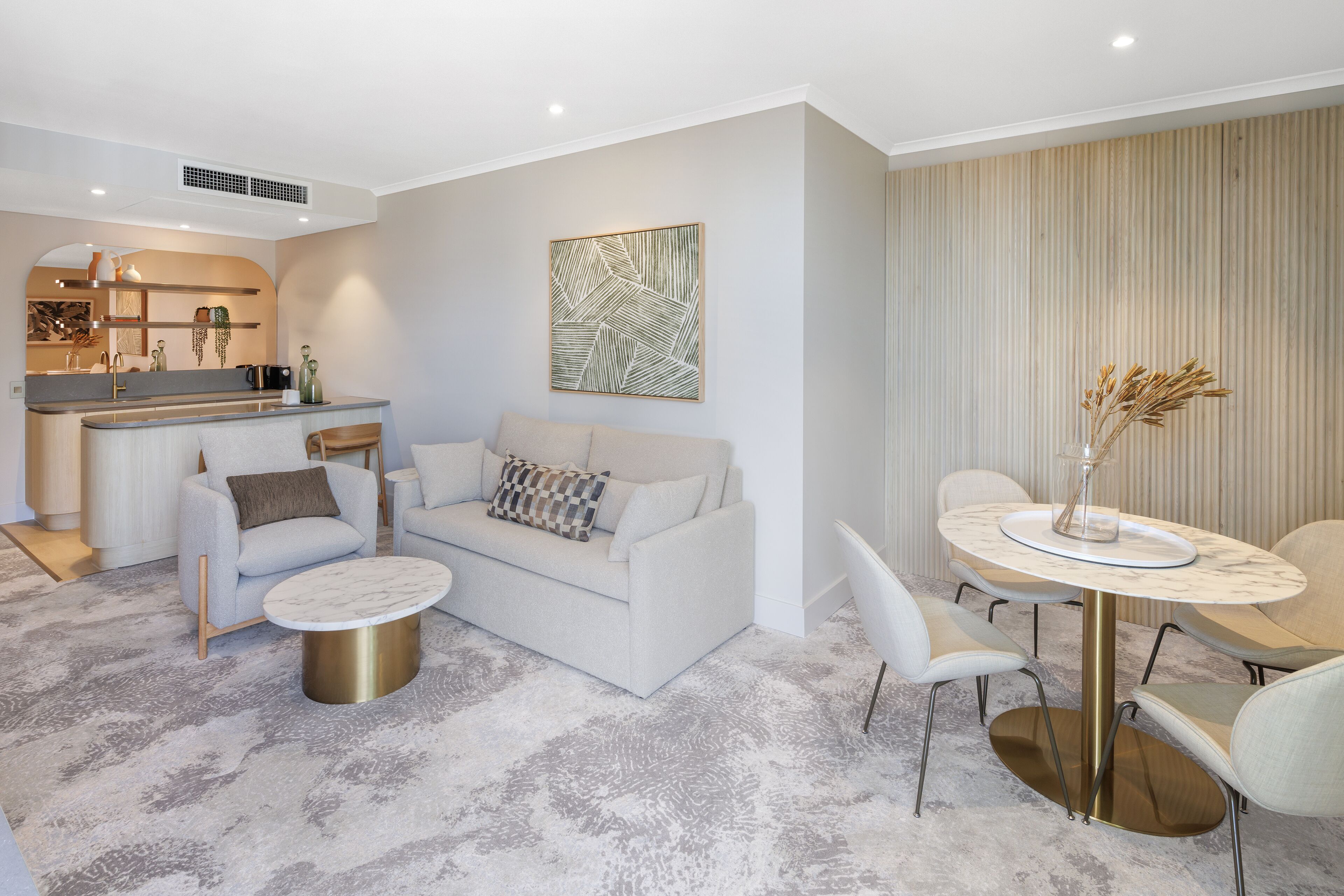 Uma sala de estar moderna com sofá, mesa de centro e área de jantar com cadeiras e uma mesa.
