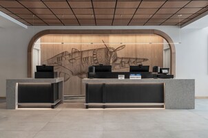 Balcão de recepção com painel de madeira e um grande desenho detalhado de um navio.