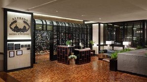 Um interior moderno com adega de vinhos, soalho em madeira e área de recepção com assentos e plantas.