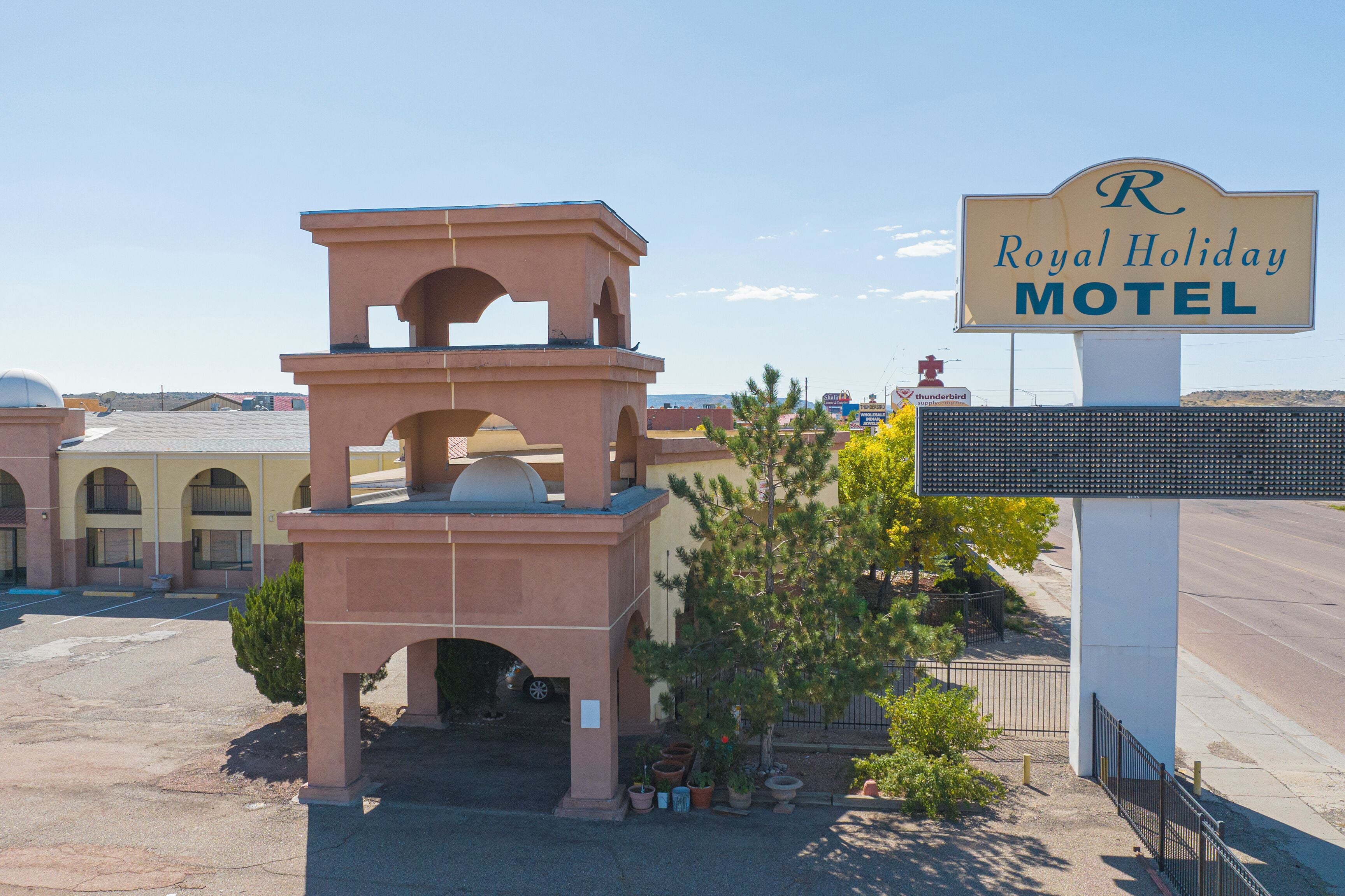 Placa de motel com o nome 'Royal Holiday Motel' e uma estrutura arquitetônica marcante com arcos e uma cúpula.