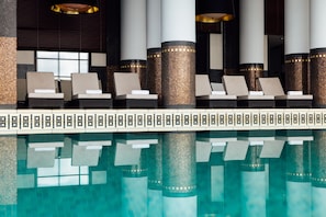 Uma área na piscina com espreguiçadeiras e uma piscina azulejada.