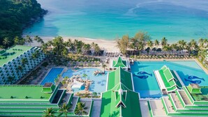 Vista aérea de um resort com uma grande piscina, várias áreas de deck e uma praia.