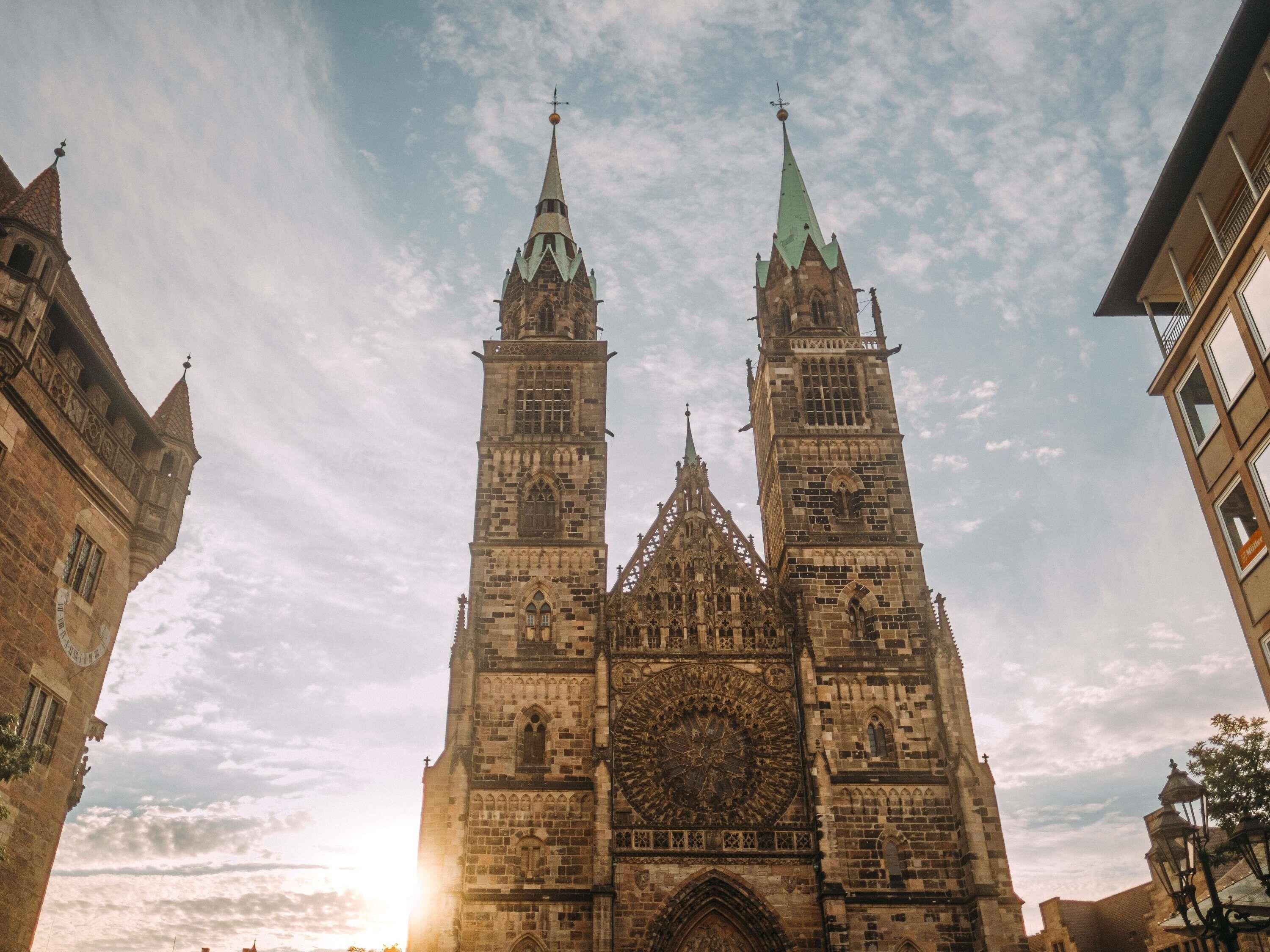 Uma catedral histórica com duas torres e um grande vitral circular.