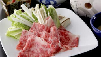 Um prato com carne crua, vegetais e cogumelos.