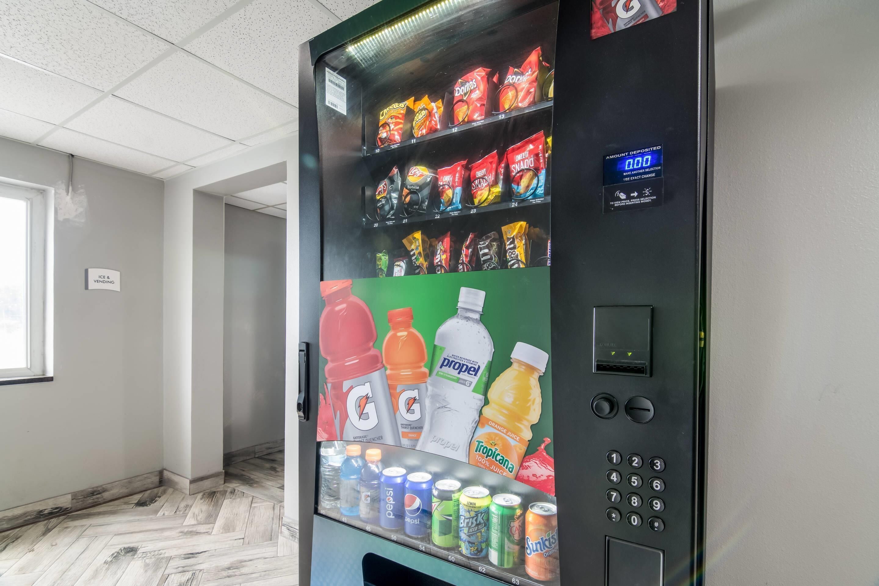 Máquina de vendas com lanches e bebidas, um teclado e um visor digital.