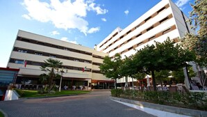 Um hotel com vários andares, um pátio central, área de estar ao ar livre e uma bandeira.
