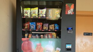 Máquina de venda automática com lanches, bebidas e Doritos.