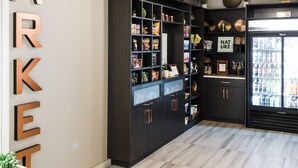 Um interior moderno com teto de madeira, uma grande estante preta e uma geladeira repleta de bebidas.