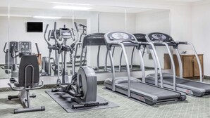 Uma academia com esteiras, elípticos e bicicleta ergométrica.