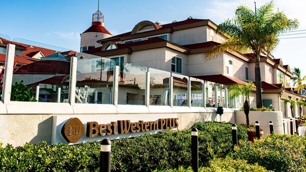 Um hotel com uma placa indicando "Best Western Plus" e uma torre com telhado vermelho.
