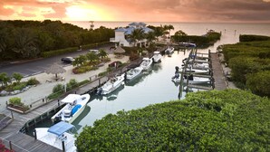 Marina com barcos atracados, um cais e um edifício com telhado azul.