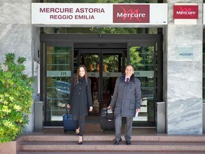 Entrada de um edifício com placa indicando Mercure Astoria Reggio Emilia.