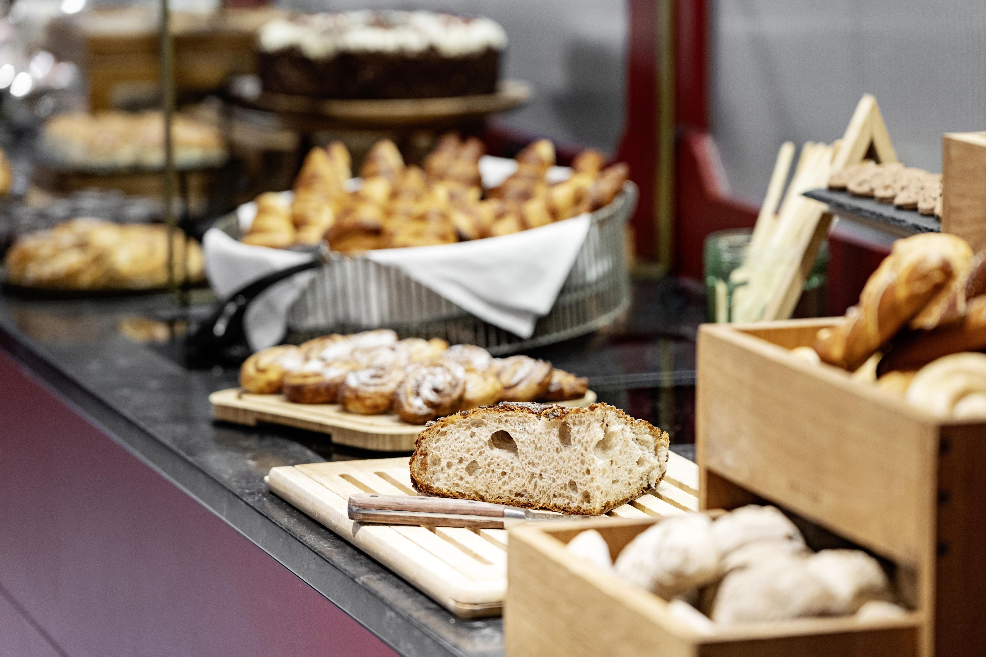 Buffet variado com pães, doces e bolos.