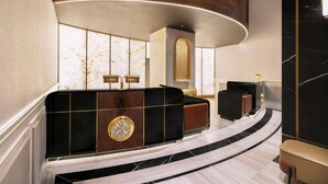 Um hall luxuoso com uma receção curva, soalho de mármore e um candelabro moderno.