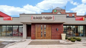 Restaurante Burger Theory com um letreiro do Holiday Inn acima.