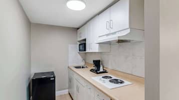 Suite, 1 cama king-size, kitchenette | Kitchenette privada | Um frigorífico (a pedido), um micro-ondas (a pedido)