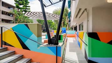 Um edifício moderno com padrões geométricos coloridos nas paredes e uma escada com grades de metal.