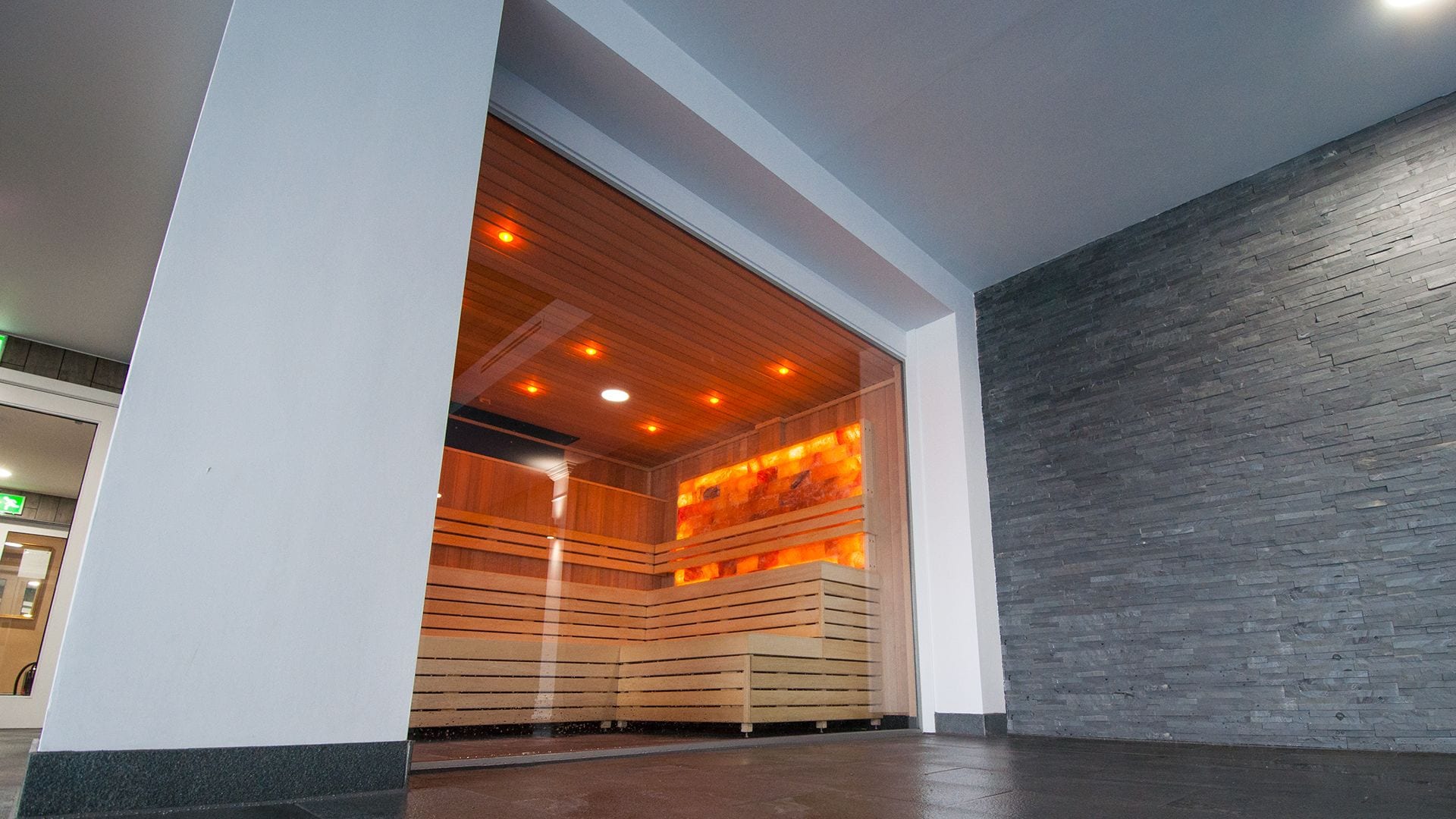 Um interior moderno com uma parede de ripas de madeira e uma parede com textura de pedra.