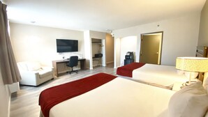Quarto de hotel com duas camas, uma escrivaninha com cadeira, televisão, guarda-roupa e máquina de café.