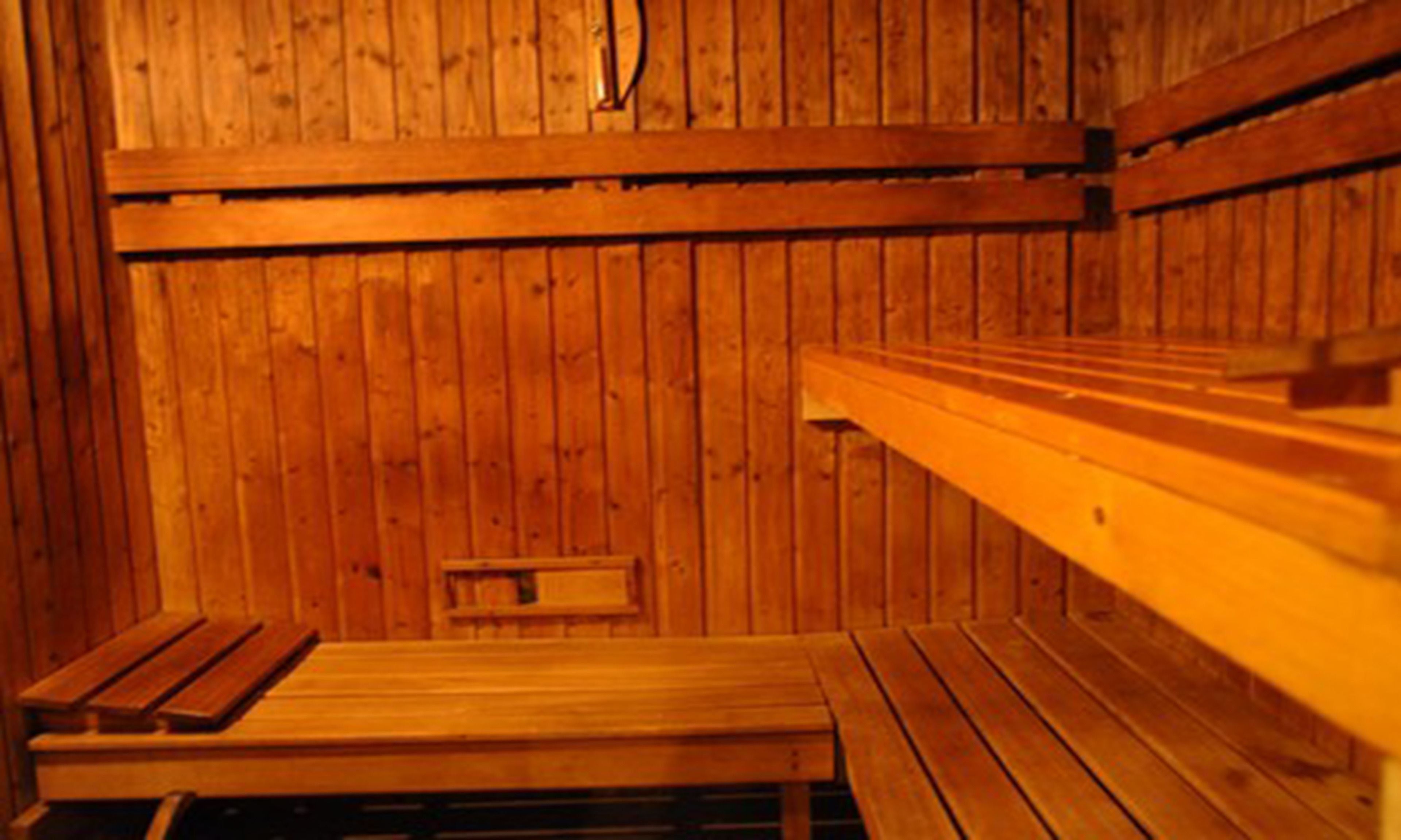 Uma sauna de madeira com bancos e parede de madeira.