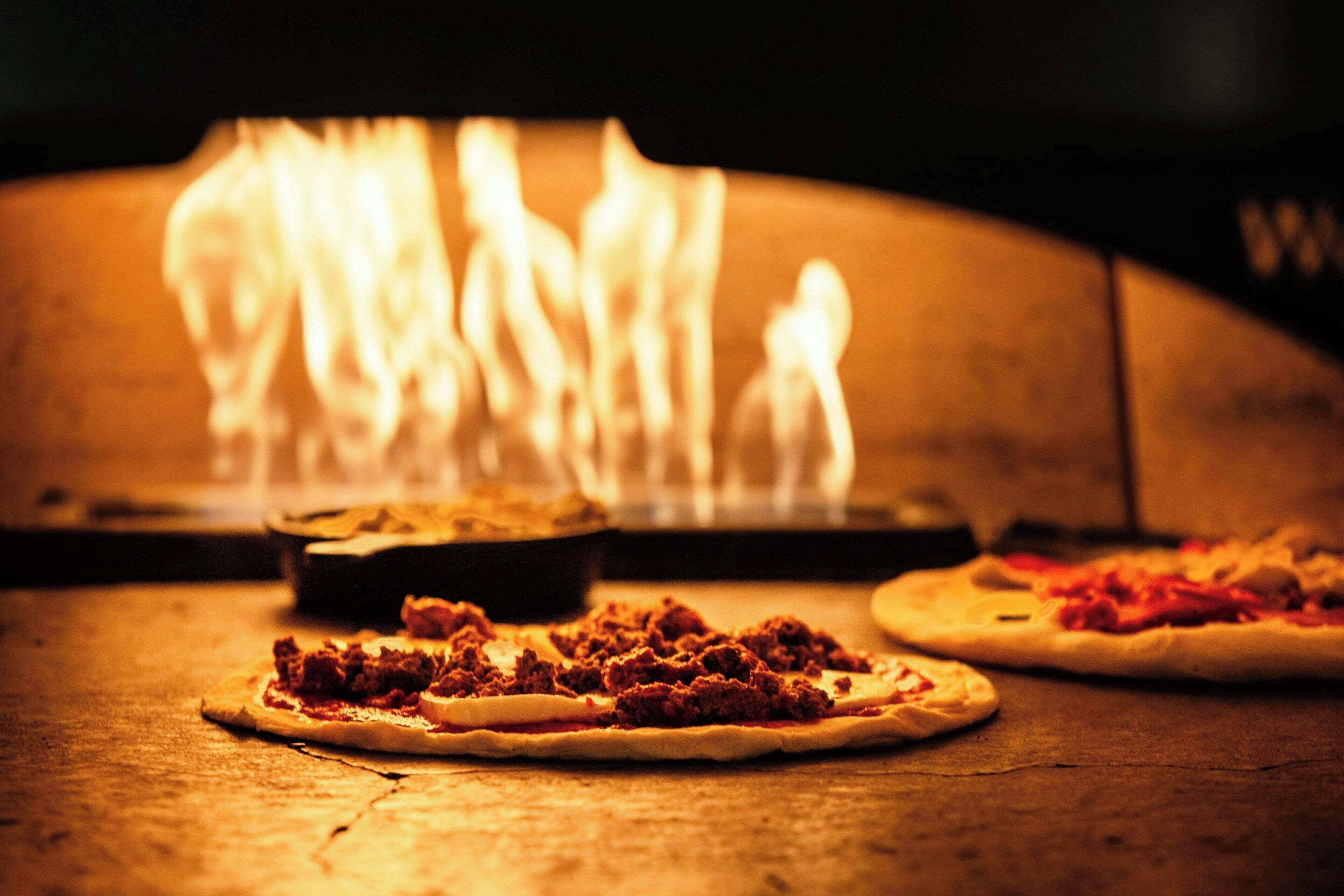 Forno a pizza com duas pizzas na frente.