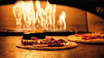 Forno a pizza com duas pizzas na frente.