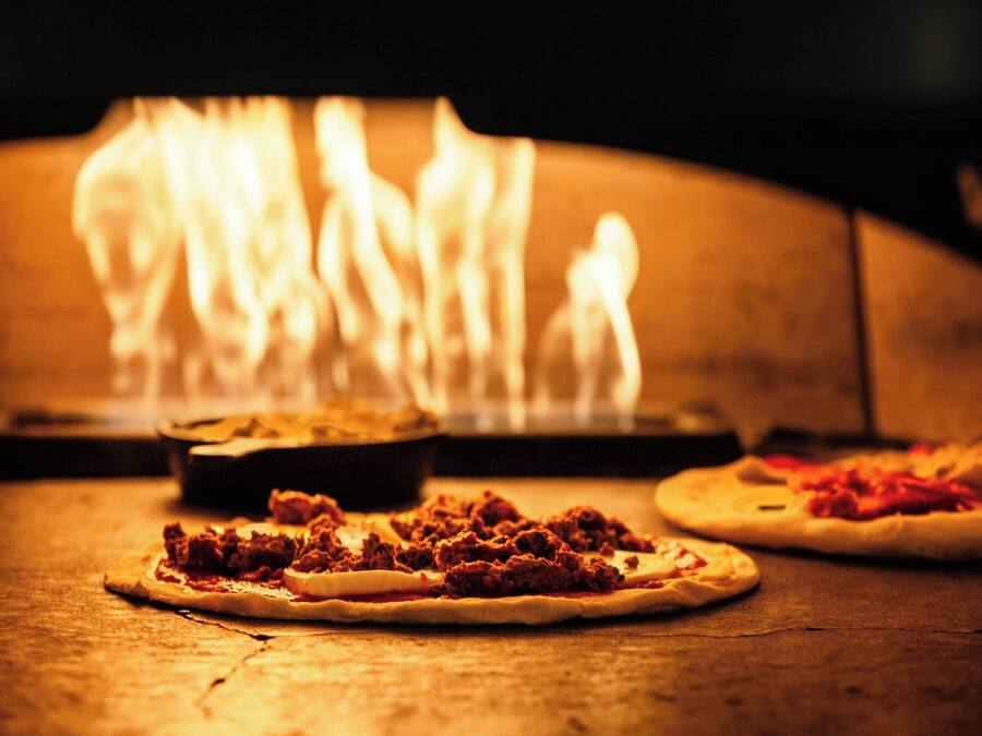 Forno a pizza com duas pizzas na frente.