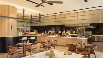Um restaurante moderno com área de bar, cadeiras de madeira e uma mesa de mármore.
