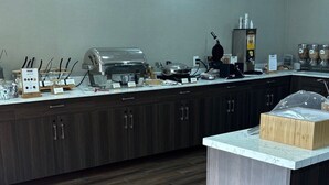 Uma cozinha moderna com bancada de mármore, armários de madeira escura e uma ilha central.