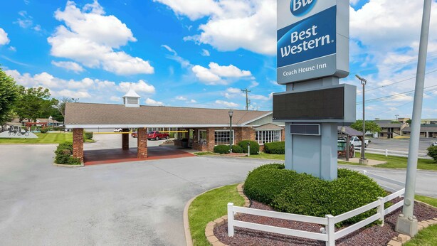 Um hotel Best Western com uma placa chamativa, área de estacionamento coberta e gramado bem cuidado.