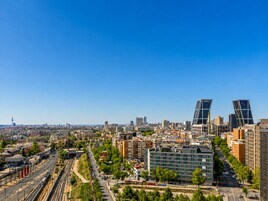 Paisagem urbana com edifícios modernos, uma estação de trem e céu claro.