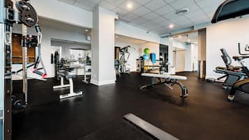 Uma academia com diversos equipamentos de exercício, incluindo esteiras e aparelhos de musculação.