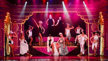 Um palco com artistas em diferentes trajes.