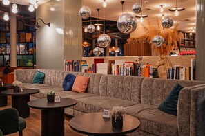 Uma área de estar moderna com sofá, mesas redondas e espelhos decorativos.
