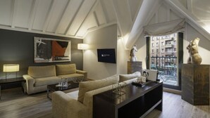 Uma sala de estar moderna com teto alto, um sofá, uma mesa de centro e uma televisão.