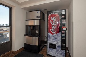 Máquina automática com logotipo da Coca-Cola e dispensador de água.